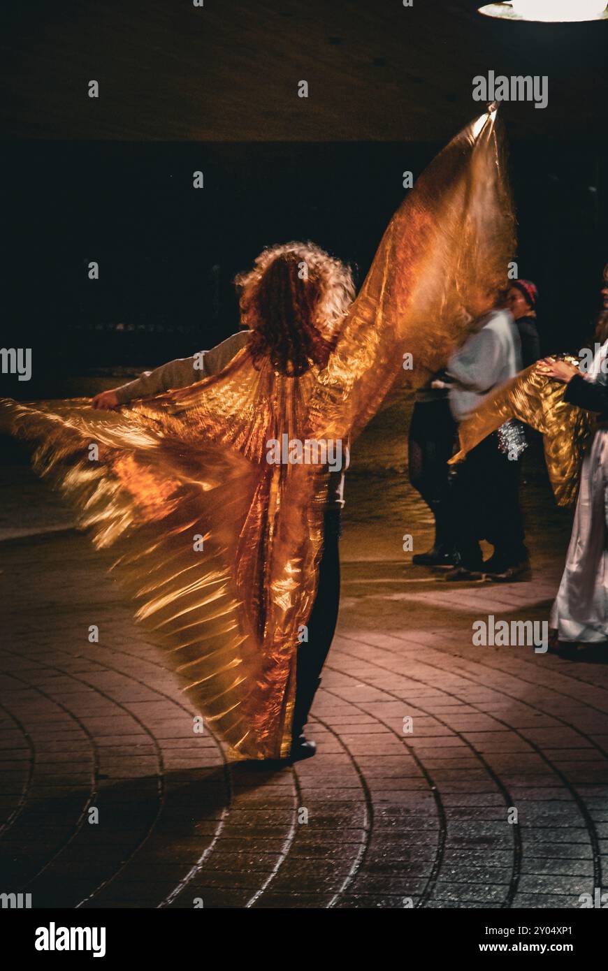 Golden angel dancing at night show Stock Photo - Alamy