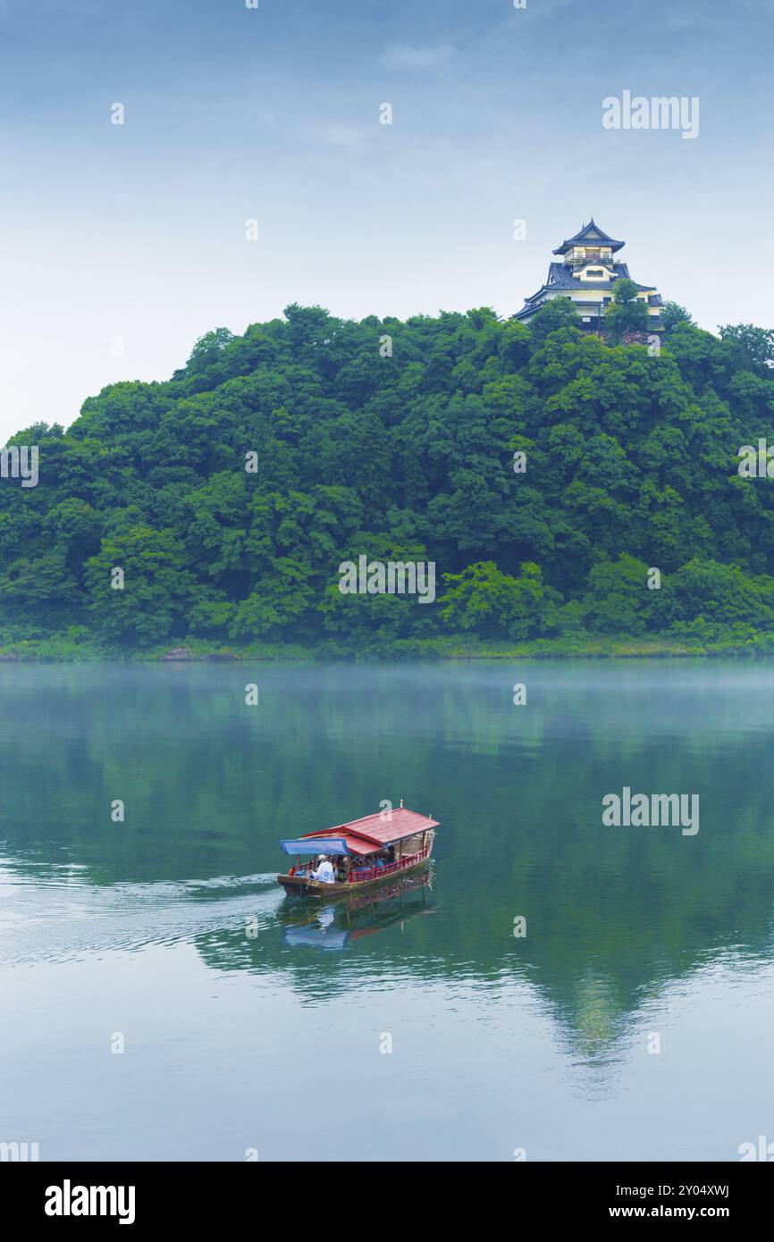 A tourist boat motors towards Inuyama Castle, one of only twelve ...