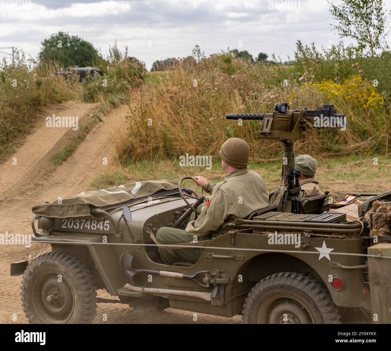 Two young men dressed as soldiers driving around in a military jeep on ...