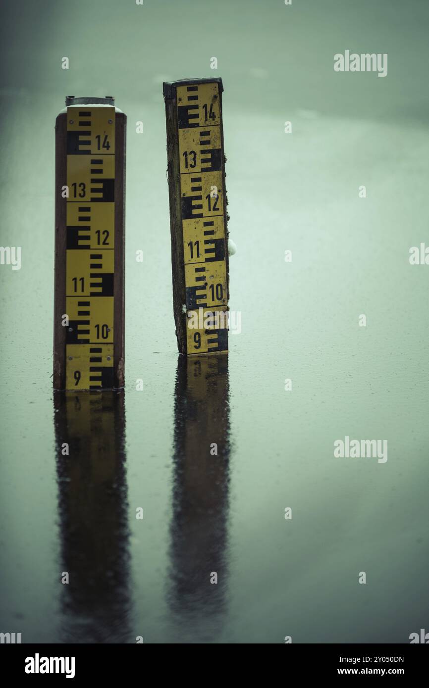 Two water level indicators in an almost frozen lake Stock Photo - Alamy