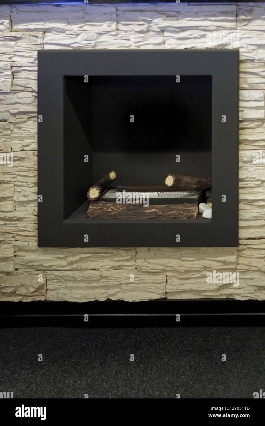 Modern black square fireplace with fake logs Stock Photo - Alamy