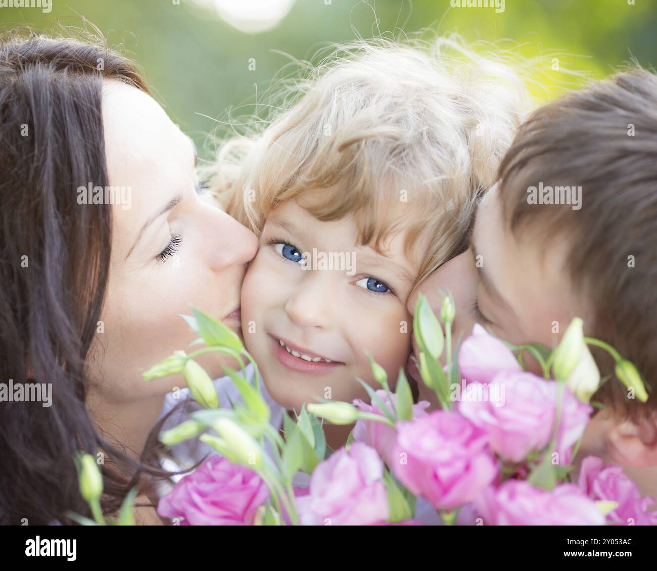 Happy family kissing child against spring green background Stock Photo ...