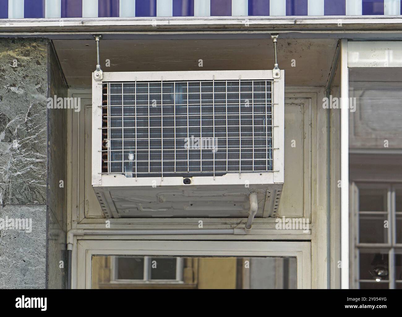 Window air conditioner unit above door Stock Photo - Alamy