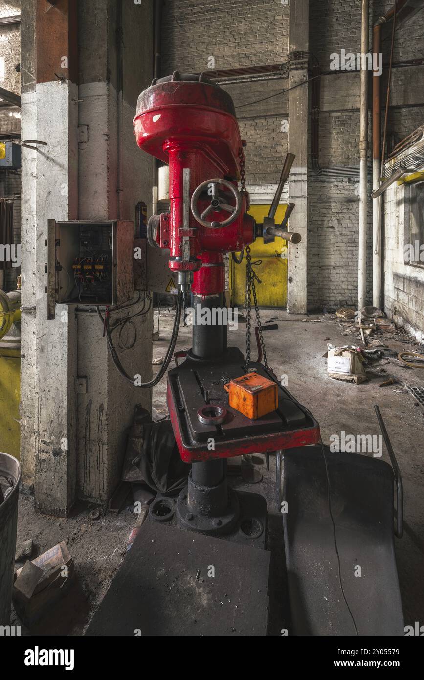 A rusty drilling machine in a neglected industrial environment with ...