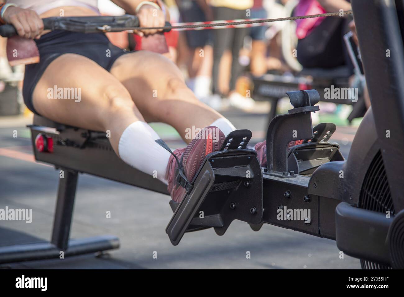 Close-up of a person using a rowing machine in the outdoor gym ...
