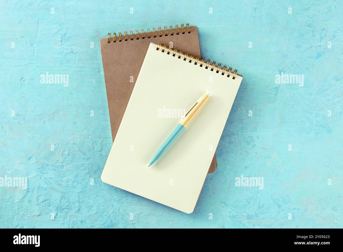 Notebook mockup with a pen, overhead flat lay shot on a blue background ...