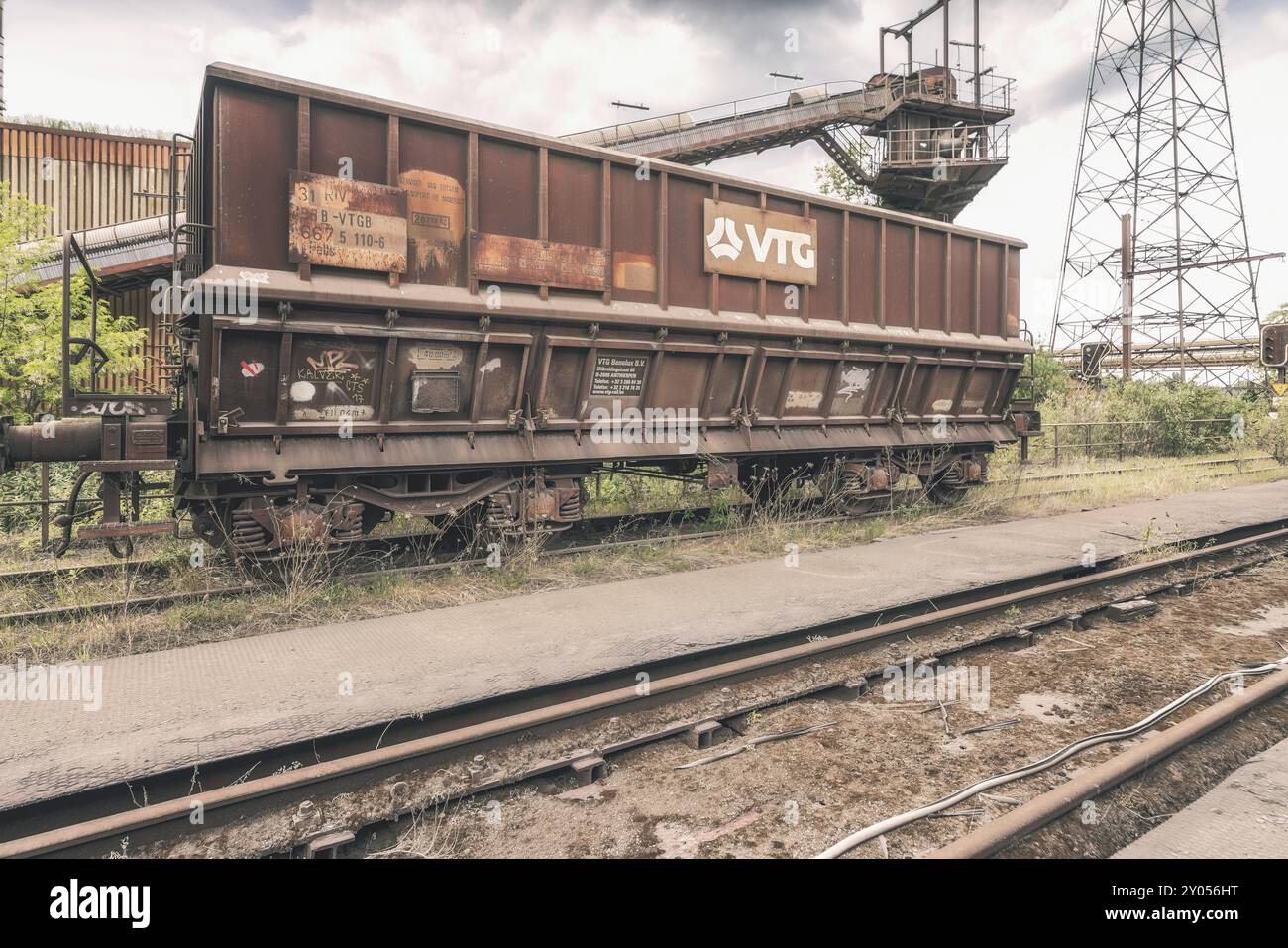 Rusty freight wagon on abandoned rails in an industrial plant, cloudy ...