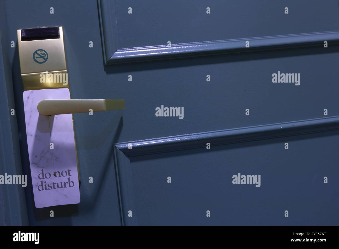 Blue painted door with 'Do Not Disturb' sign and gold-coloured handle ...