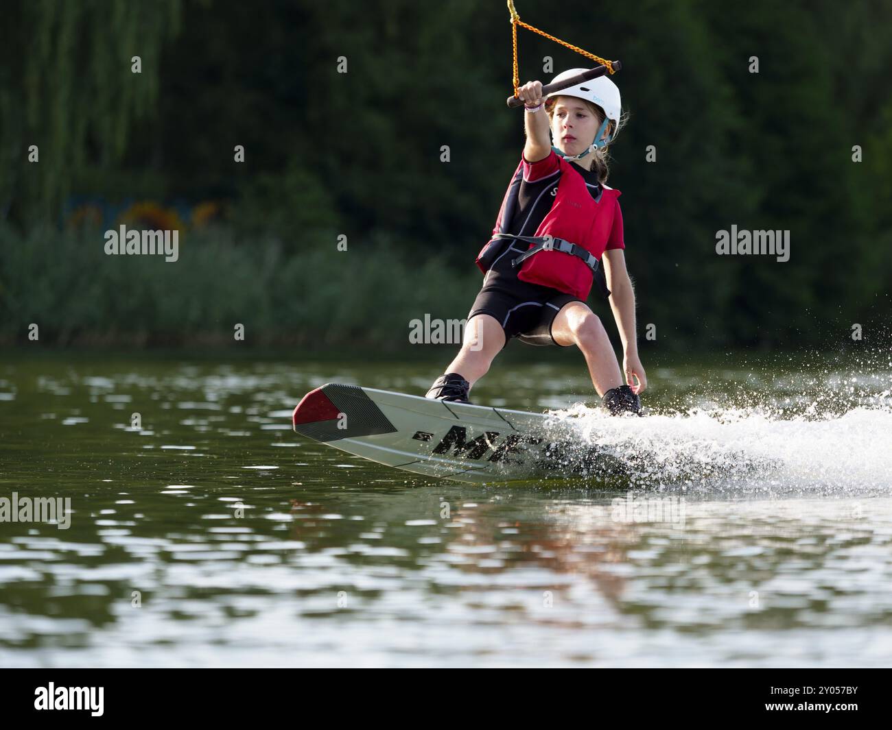 Boy or girl with wakeboard in the lake, water sports, water skiing in ...