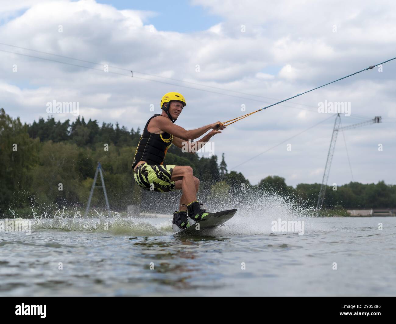 Sporty man with wakeboard, water sports, water skiing and wake park ...