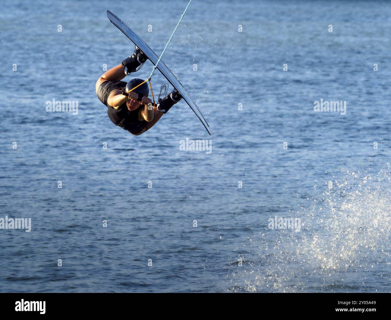 Sporty woman makes Raley with wakeboard over the lake, water sports and ...