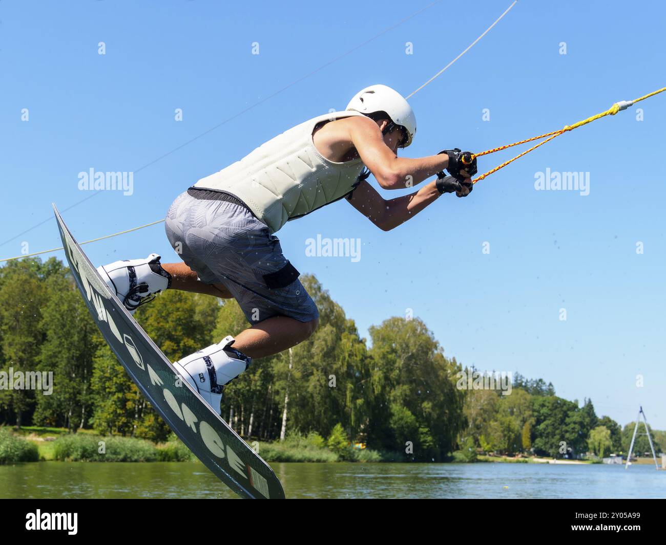 Boy with wakeboard during jump and jump start Stock Photo - Alamy
