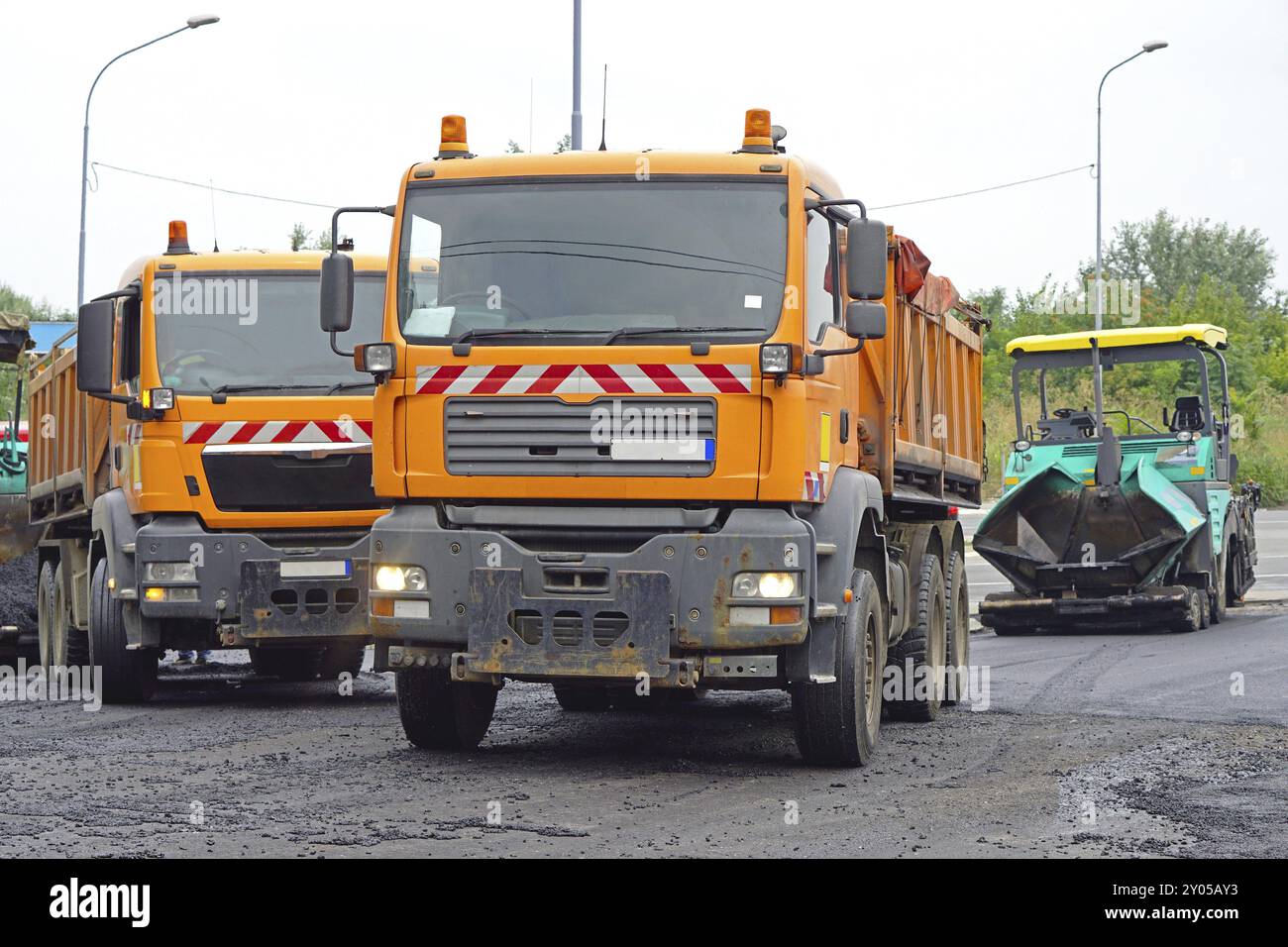 Road works trucks with asphalt and surfacing machine Stock Photo - Alamy