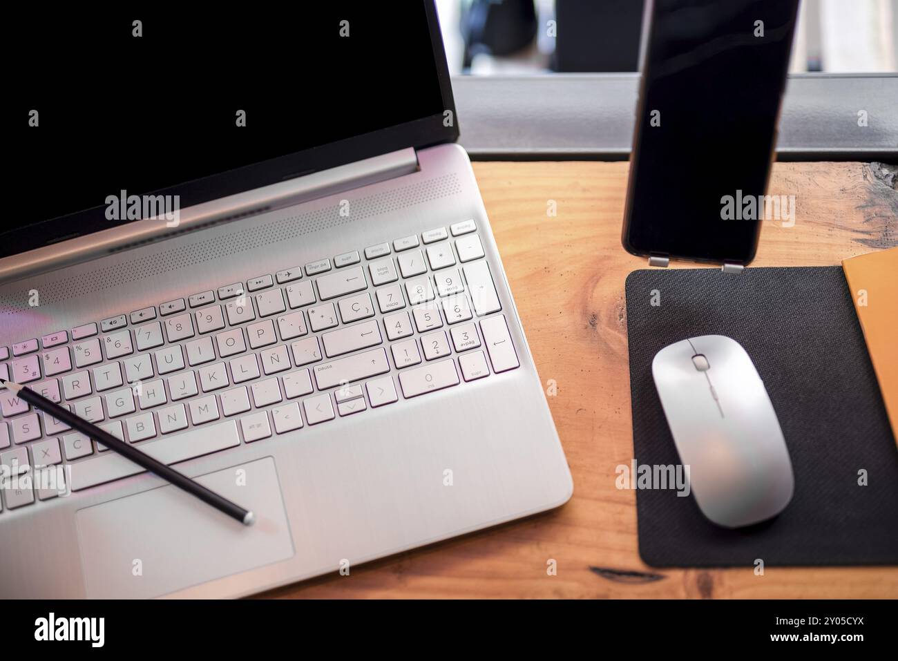 In a neatly organized desk, a sleek laptop with a vibrant screen takes ...