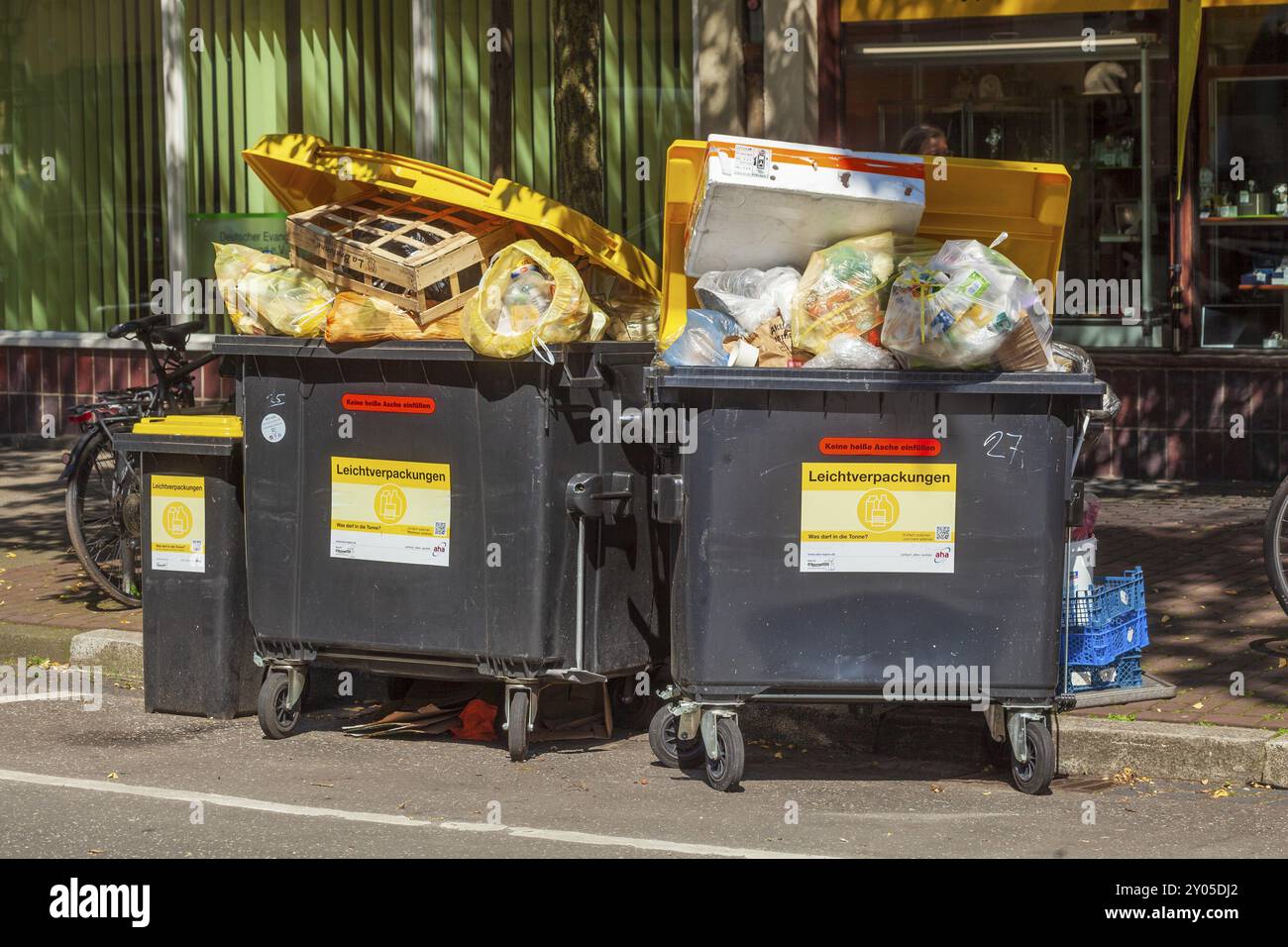 Overfilled waste containers for lightweight packaging standing on the ...