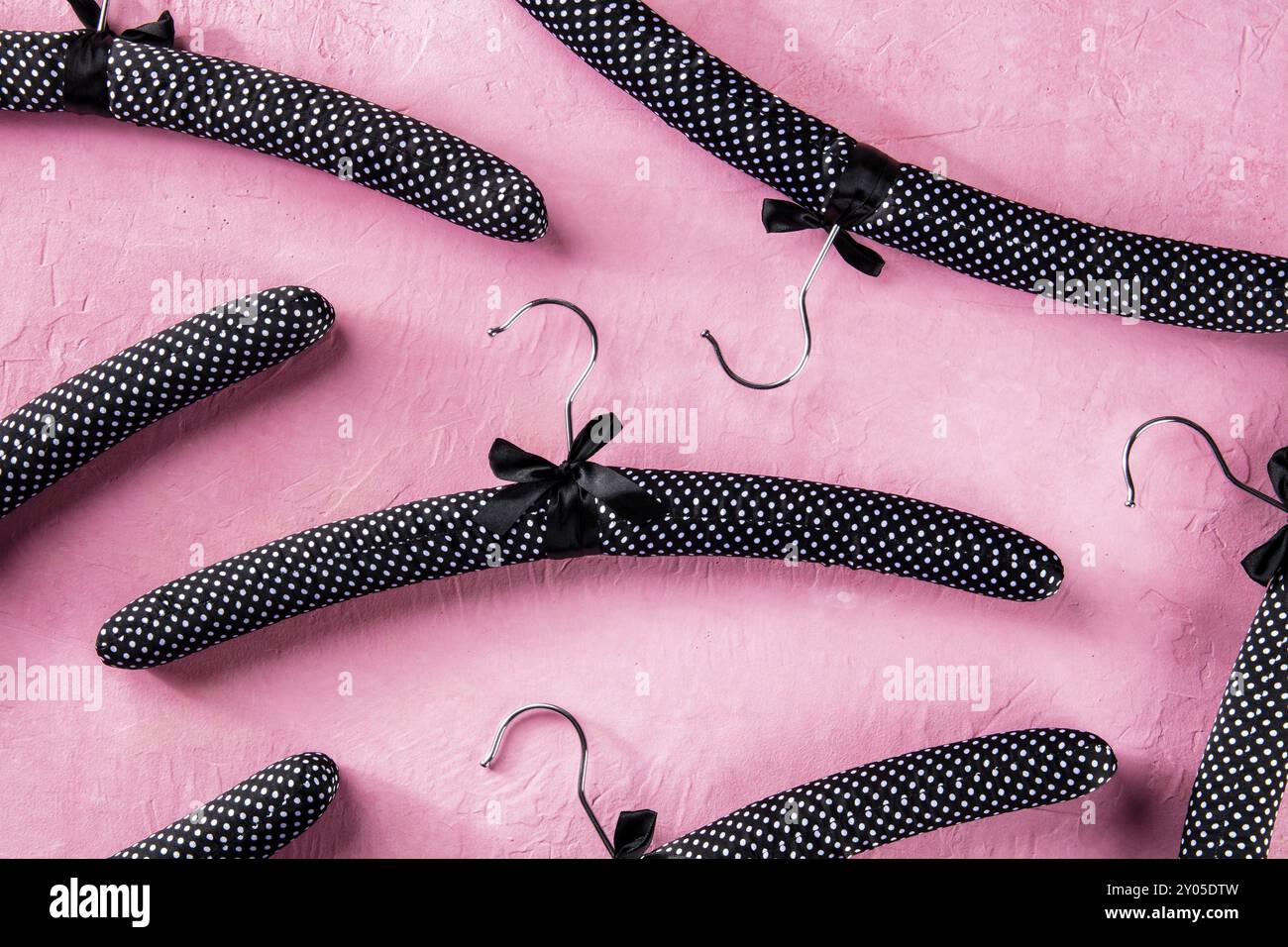 Fashion collection concept. Black satin hangers for delicate clothes, a ...