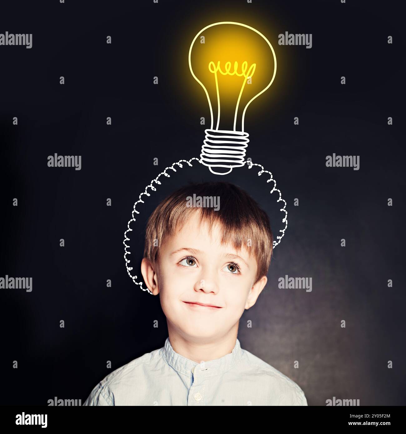 Little child boy student with yellow light bulb and question marks on ...