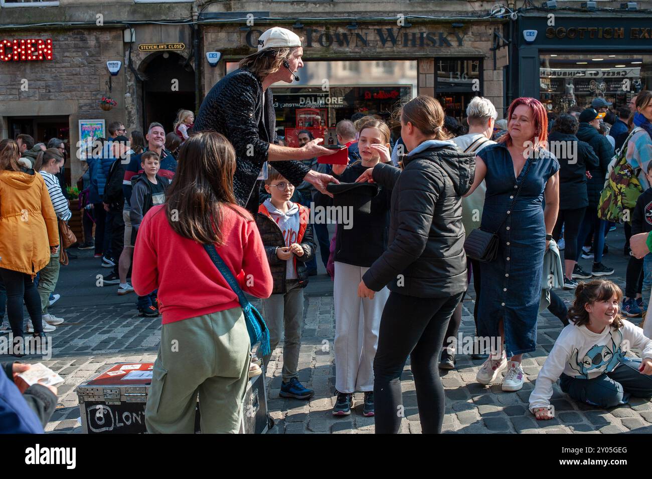 A street performer collecting money after the show at Edinburgh Fringe ...