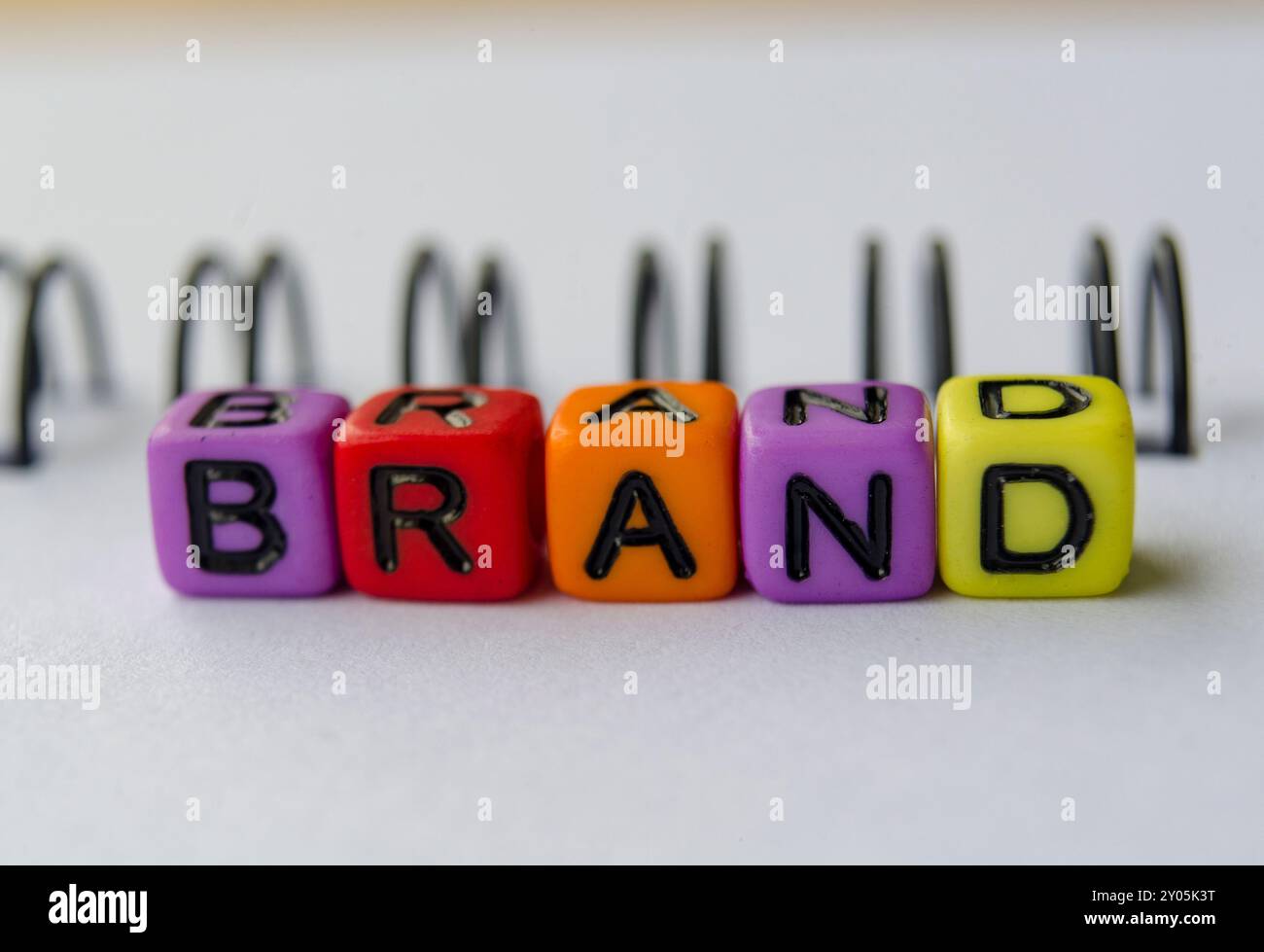 Close up of BRAND text representing on small square toy on white ...