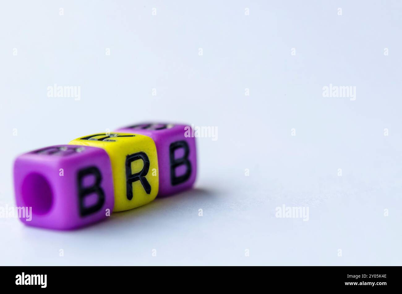 BRB text representing Be Right Back on small square toy on white ...