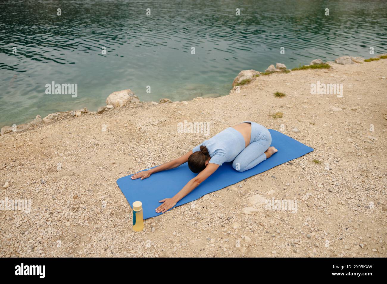Engaging in a Relaxing Yoga Pose by the Serene Waters Edge to Achieve ...