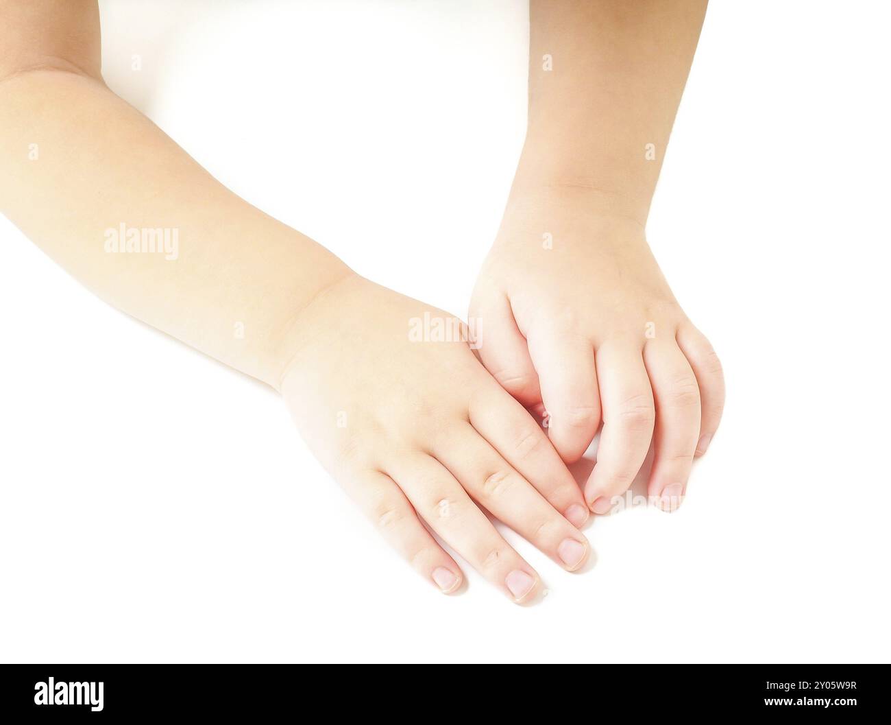 Toddler leaning towards on a white table, with hands together Stock ...