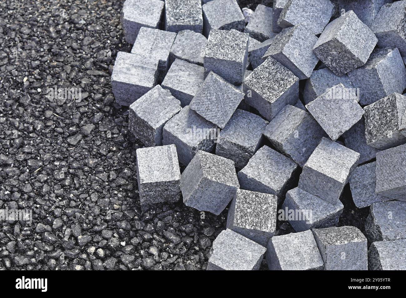 Big bunch of cobblestone bricks at new asphalt Stock Photo - Alamy