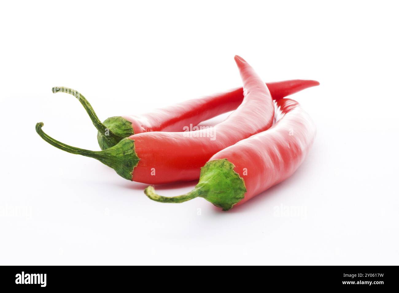 Three red peppers isolated over white Stock Photo - Alamy