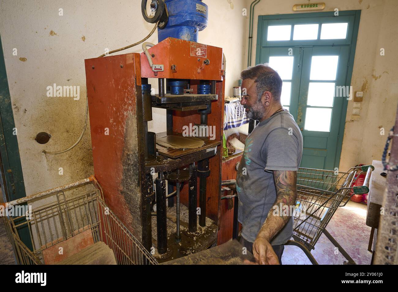 A man operates a brick press in a workshop, bricks and metal machine ...