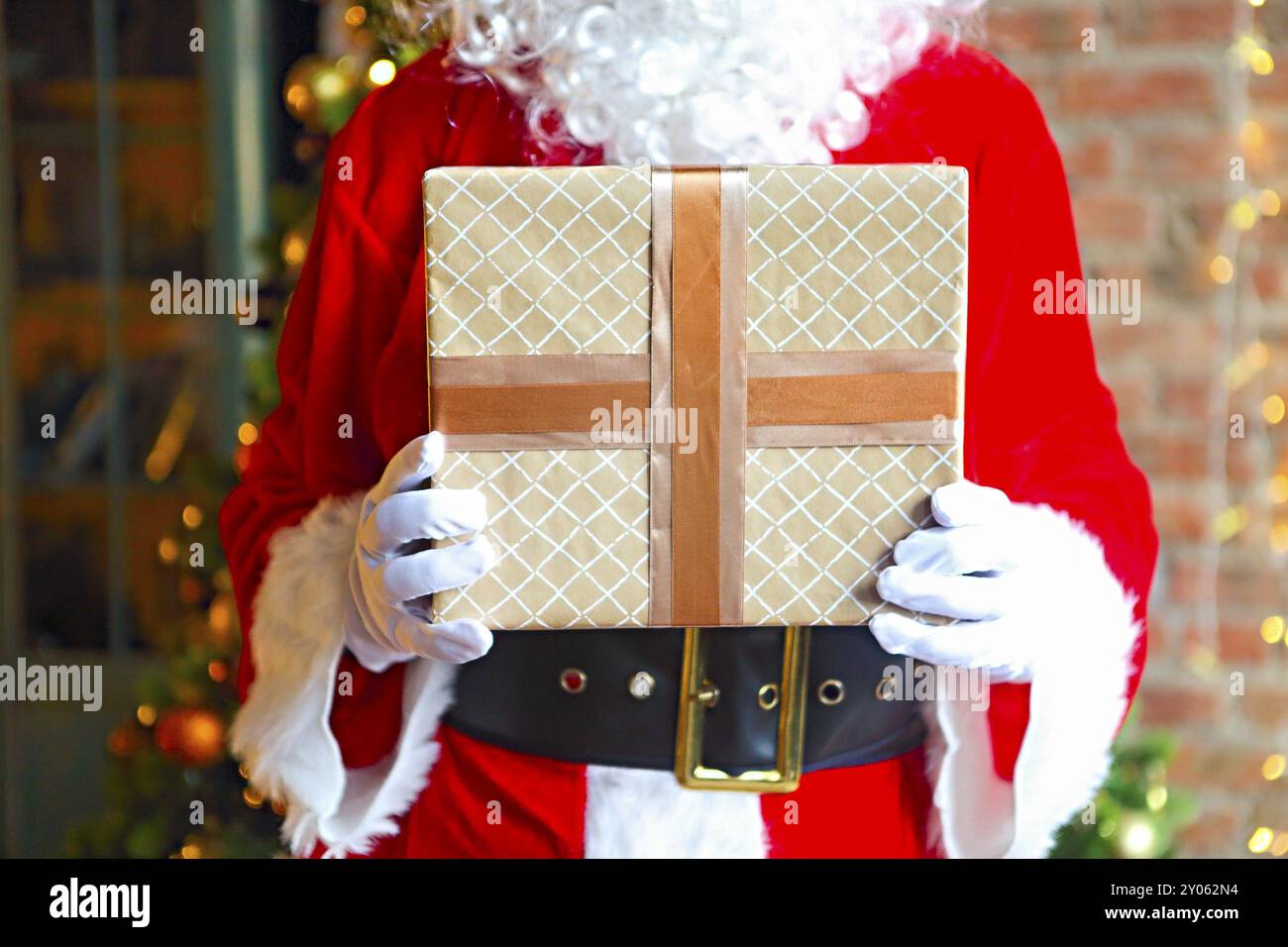Santa Claus secretly putting gift boxes under the Christmas tree. Xmas ...