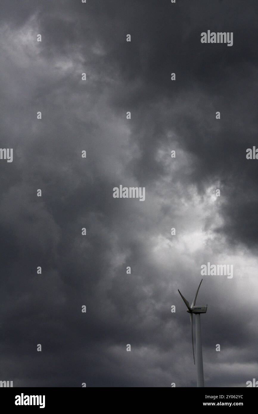 Wind turbine in front of dark clouds Stock Photo - Alamy