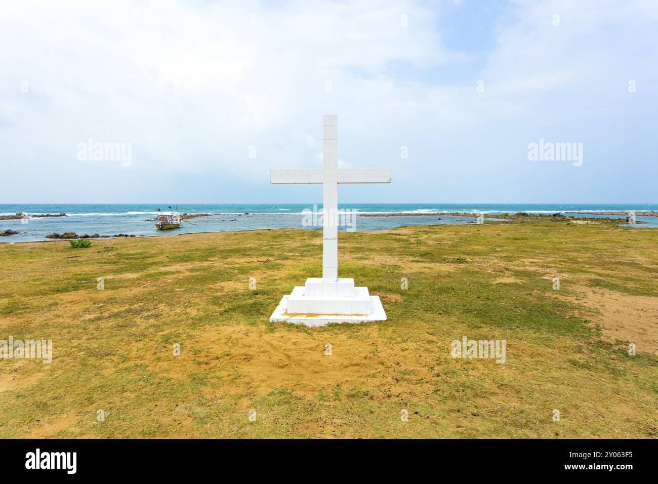 White cross is planted outside of Saint Thomas Church along the ocean in Point Pedro, Jaffna ...