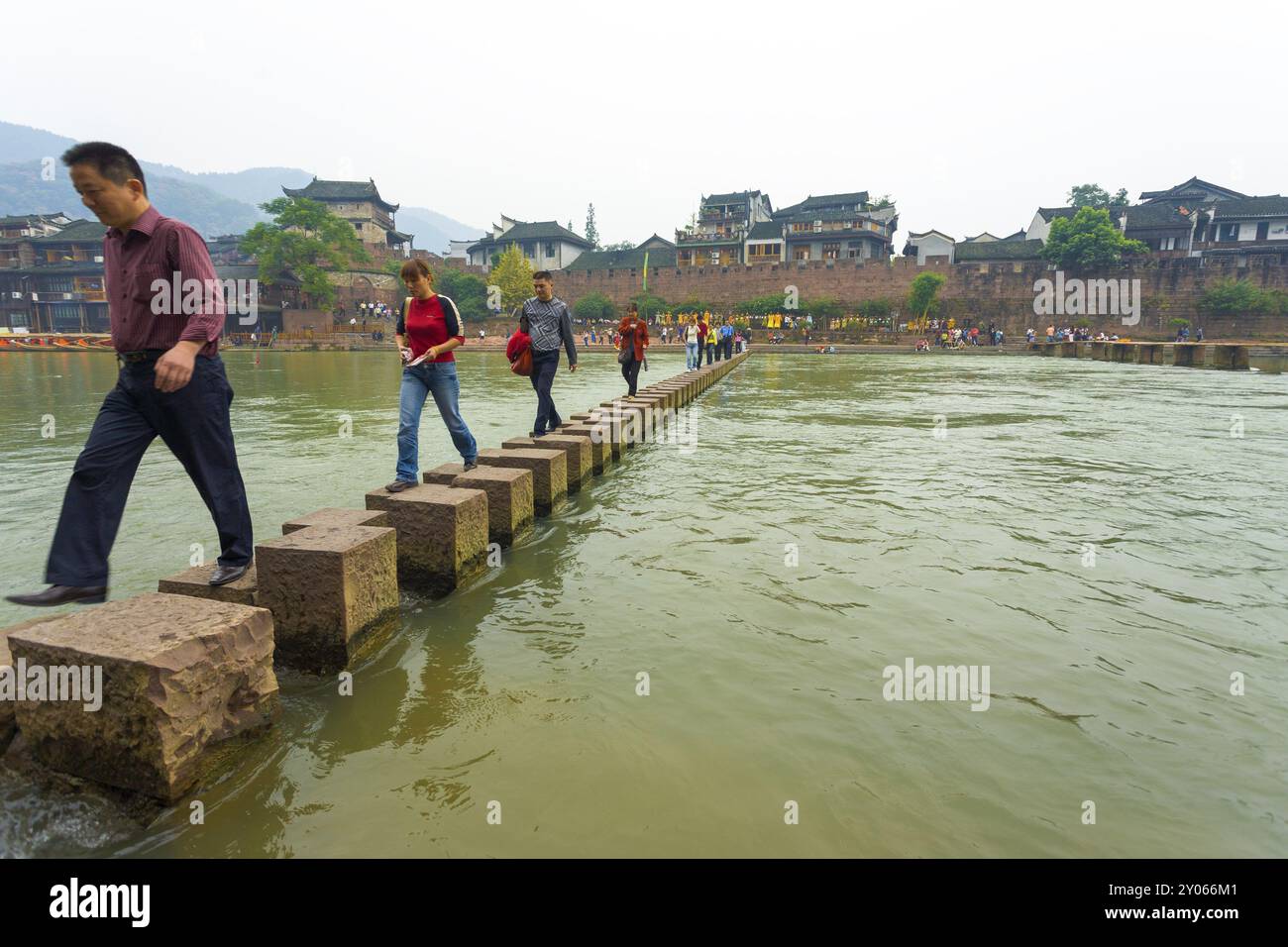 Fenghuang, China, September 10, 2007: Chinese tourists crossing the ...