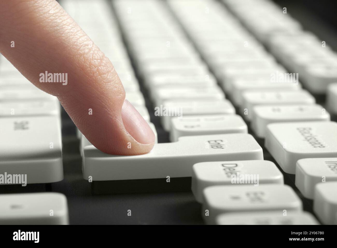 Finger pushing enter button on computer keyboard. Side view Stock Photo ...