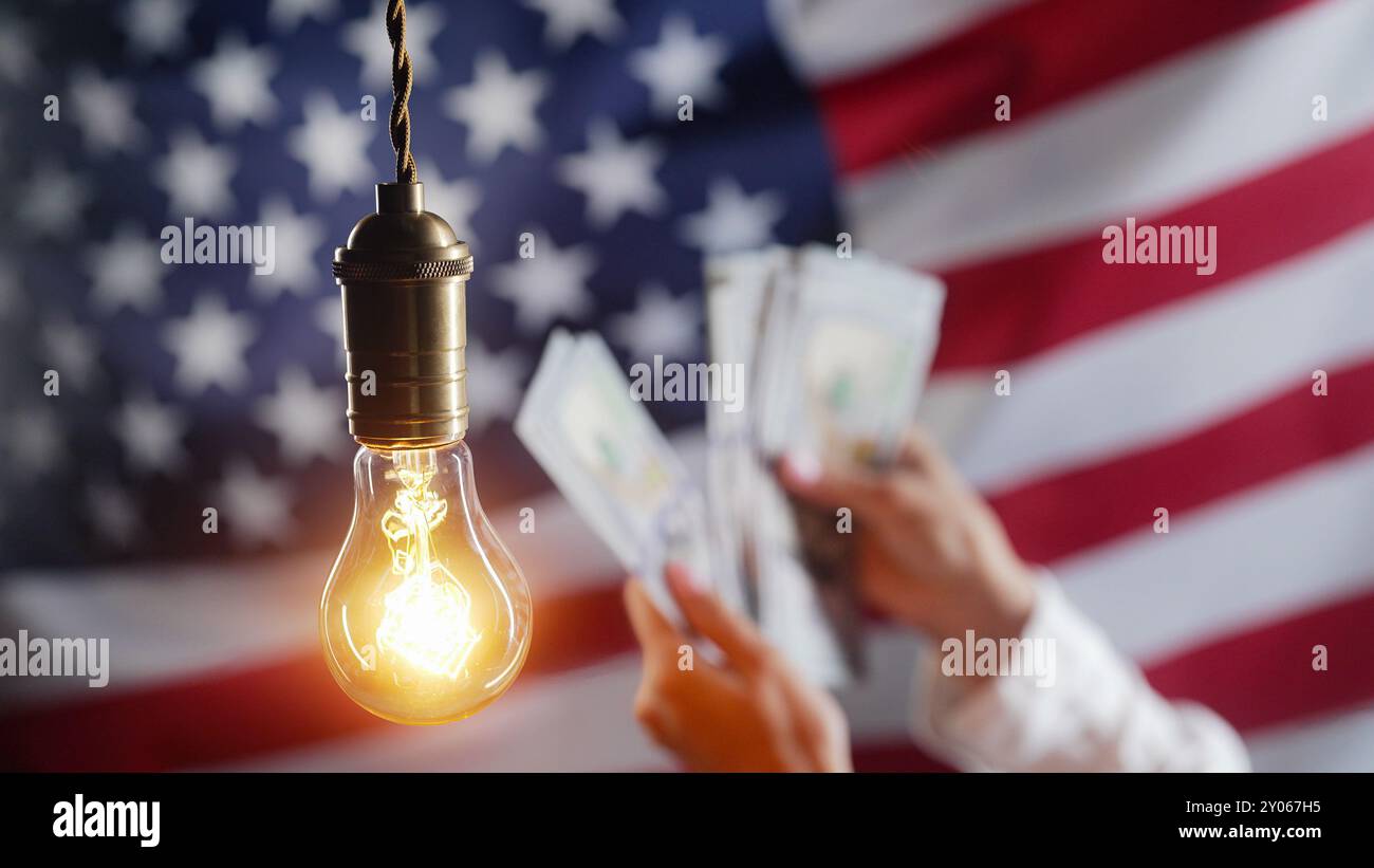Glowing Edison light bulb on american USA flag background. Woman ...