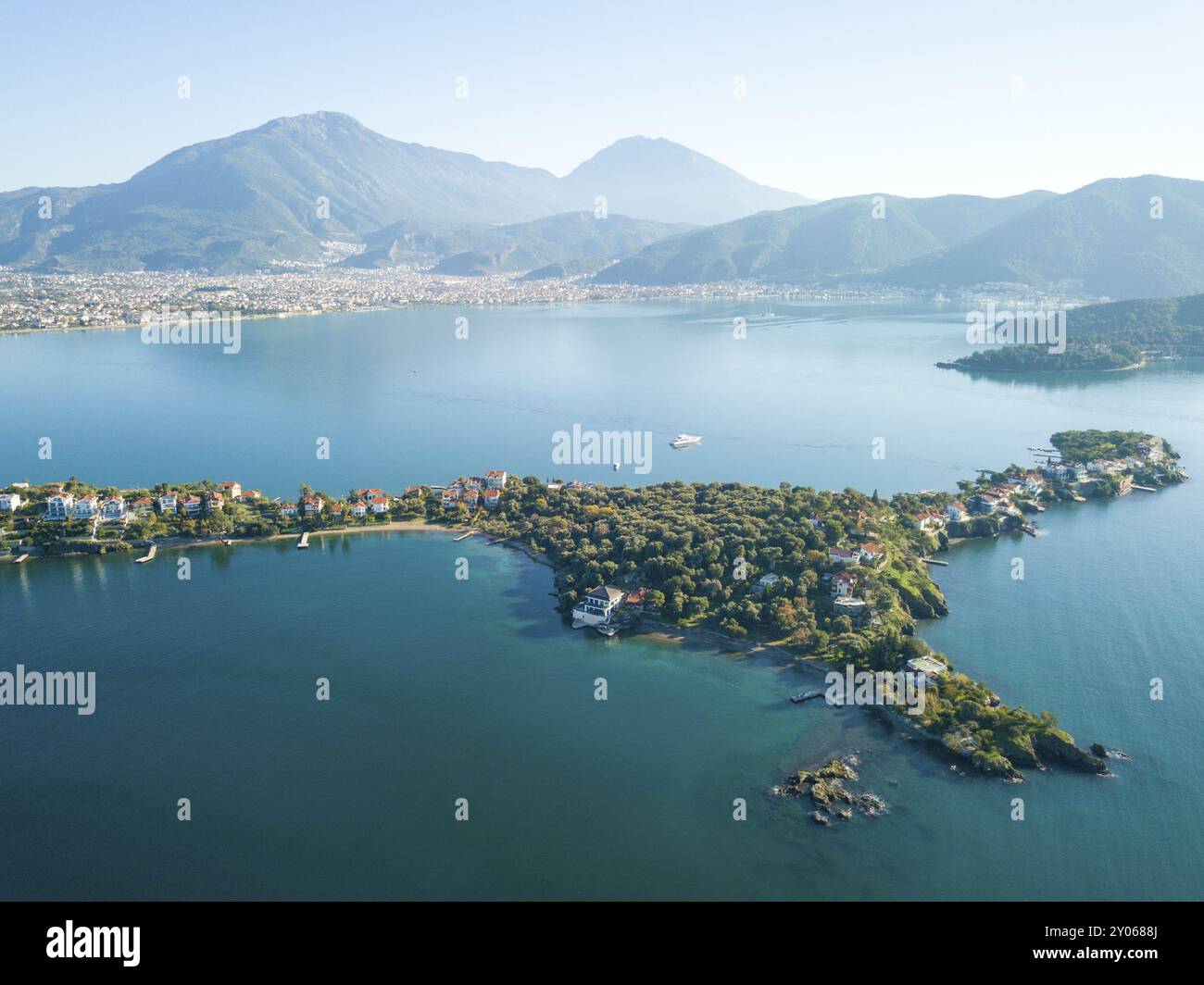 Drone aerial view of mountains and city behind Fethiye Adasi Island in ...