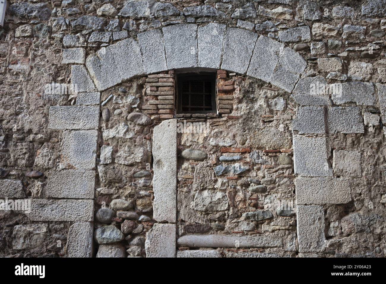 Medieval stone wall with inbuild arch and small window Stock Photo - Alamy