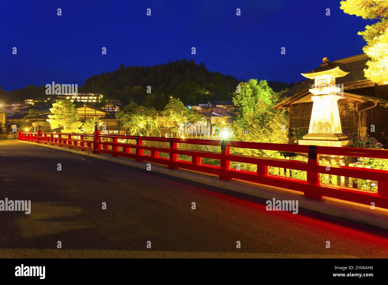 Illuminated stone lamp and bright red Naka-Bashi bridge fence, asphalt ...