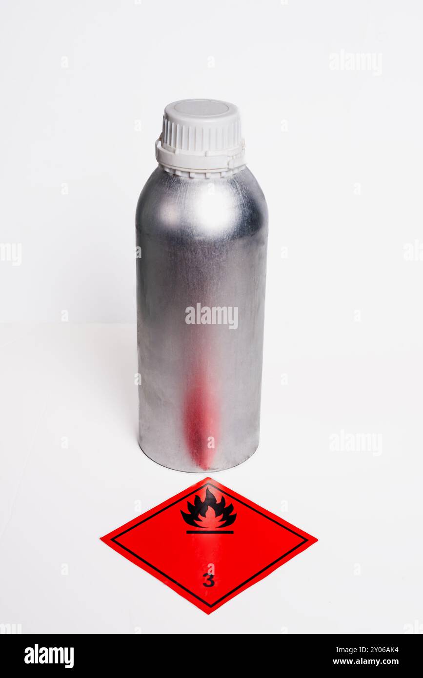 Aluminum bottle for sampling next to a label for flammable liquids ...