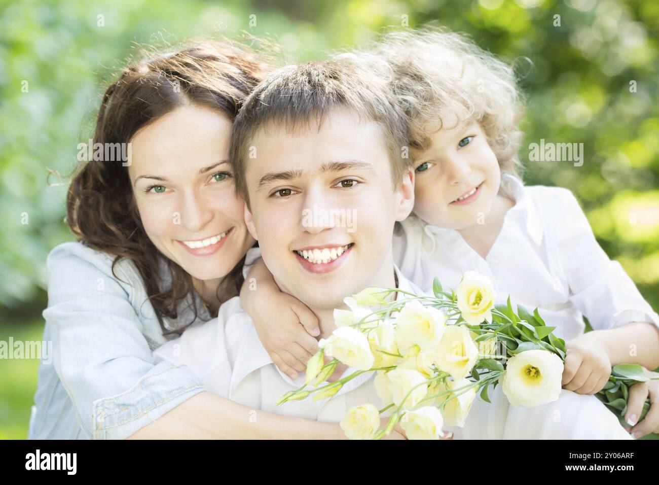 Happy family with bouquet of spring flowers against blurred green ...