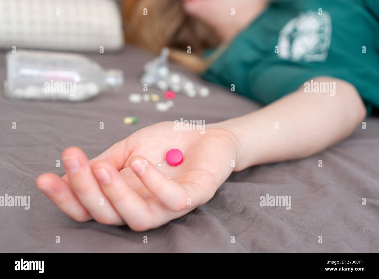 Girl overdosing on medication. Hand with pills laying on bed. Overdose ...