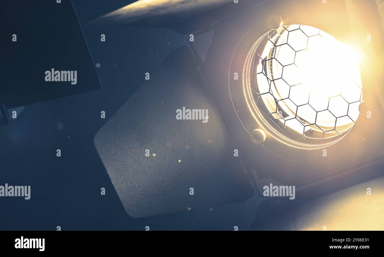 Professional orange studio spotlight hanging on the ceiling. Lighted ...