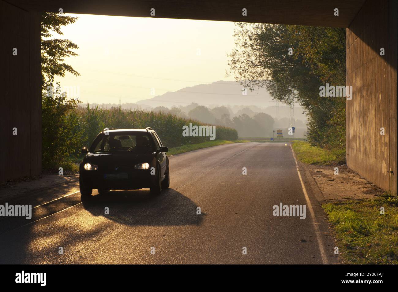 Car drives under a bridge in the morning light Stock Photo - Alamy