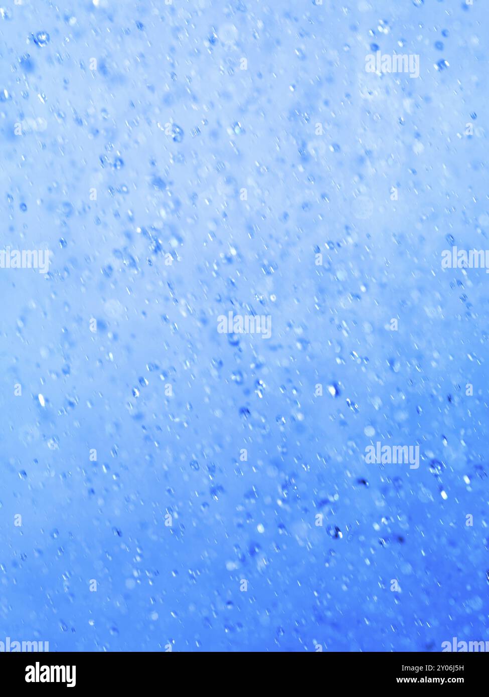 Closeup of blue spraying water droplets abstract blue background ...