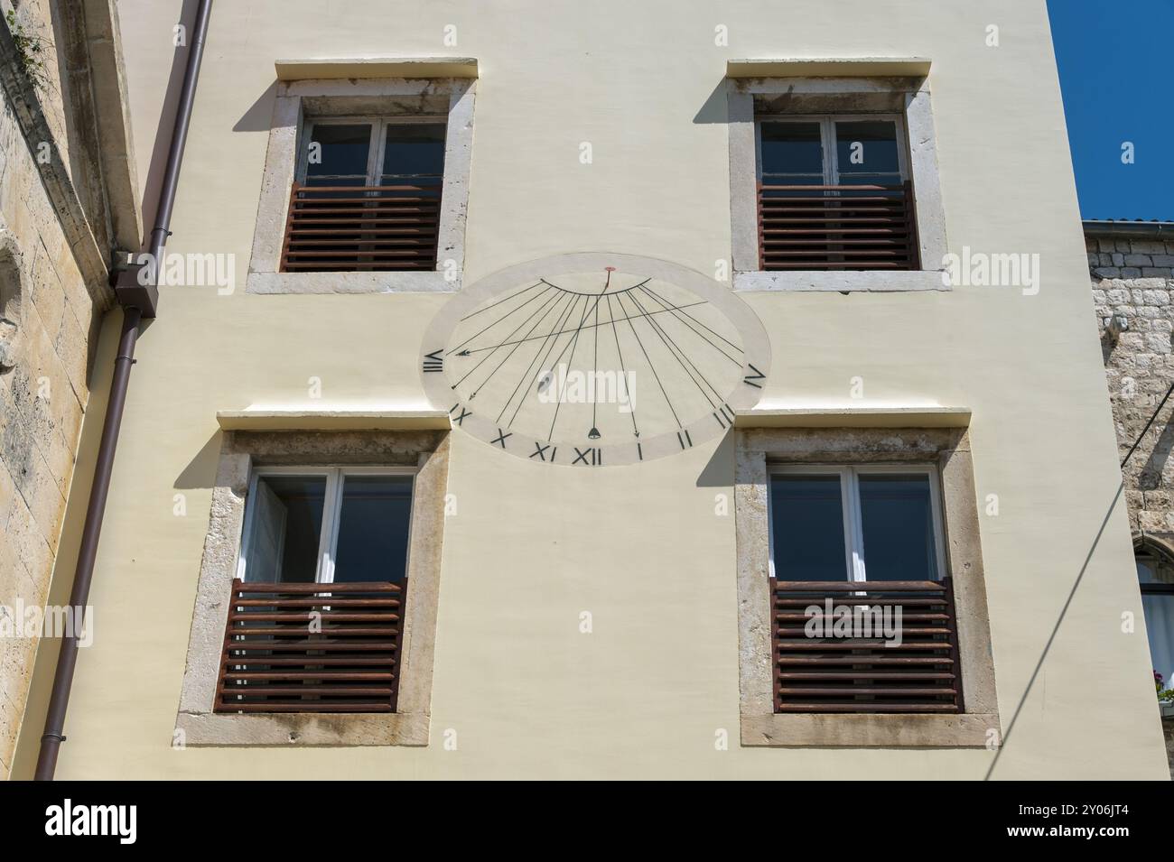 House wall with sundial and four windows Stock Photo - Alamy