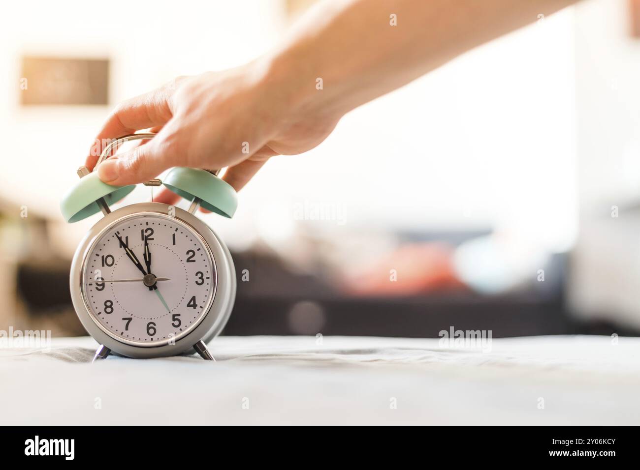Man is pushing an alarm clock, sunshine in the morning, blurry ...