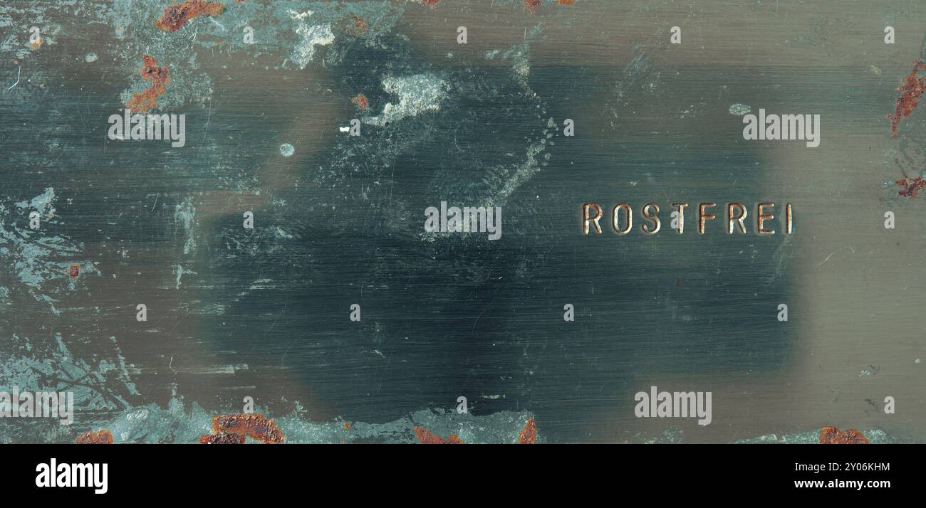 German word stainless on a rusty steel background, texture background ...