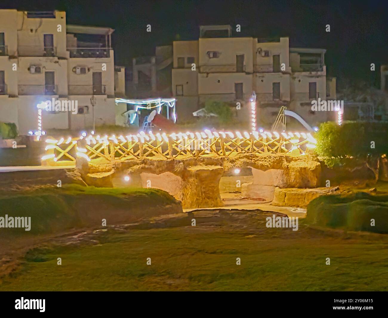 pedestrian bridge and night lights of a landscape in front of the beach ...