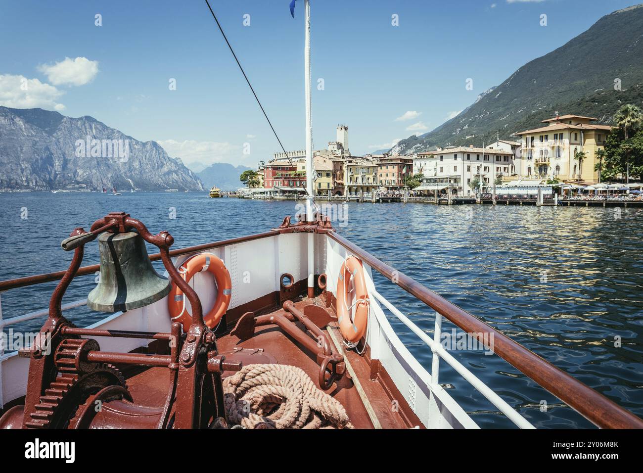 Bow of a boat with boat bell on a cruise tour. Blue water, mountain ...