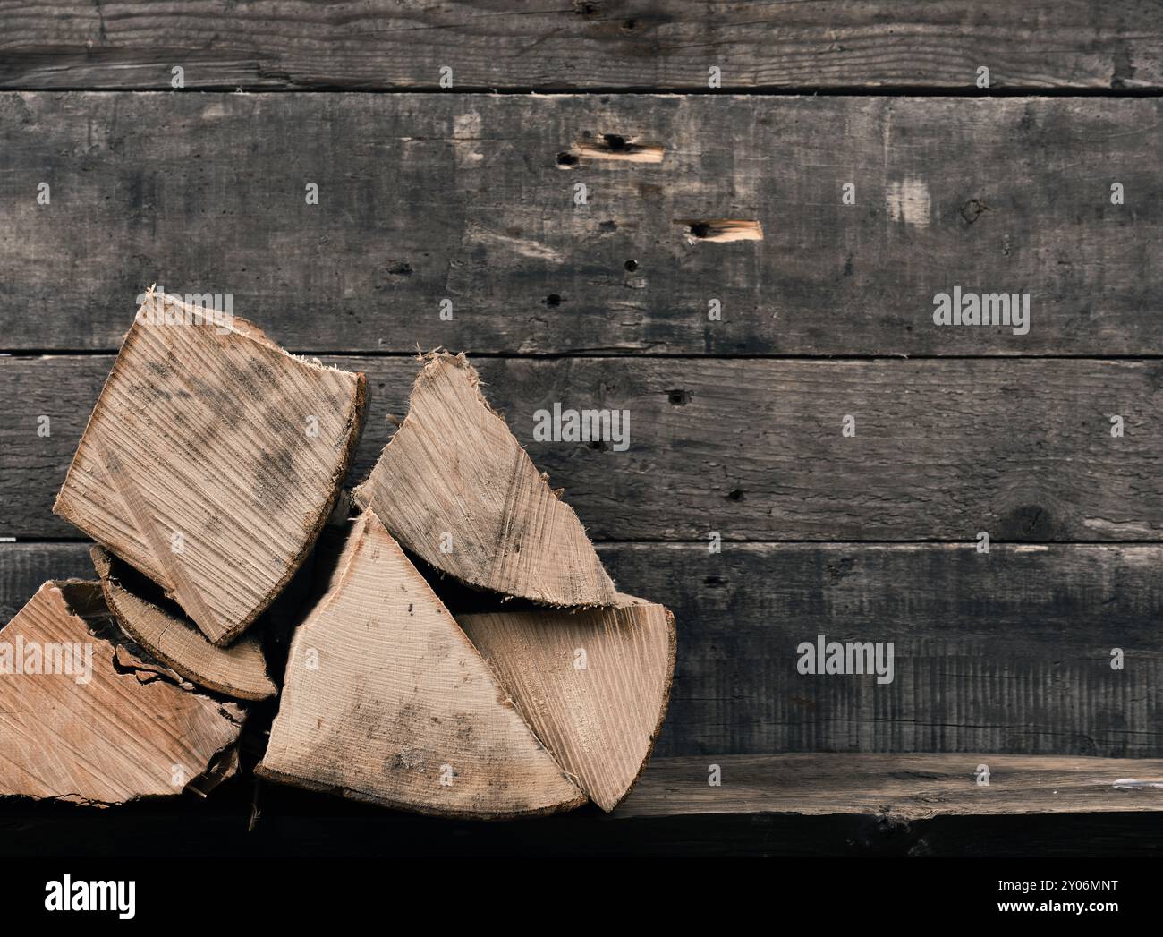 Pile of beech fire wood on a rustic wooden wall with space for your ...